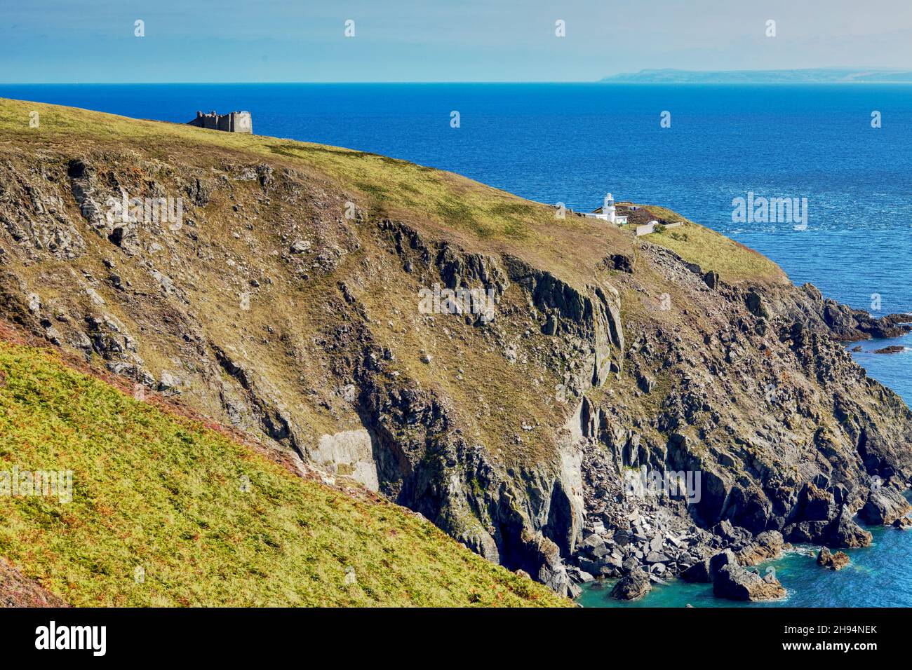 Marisco Castle and South Light lighthouse high up on top of cliffs on ...