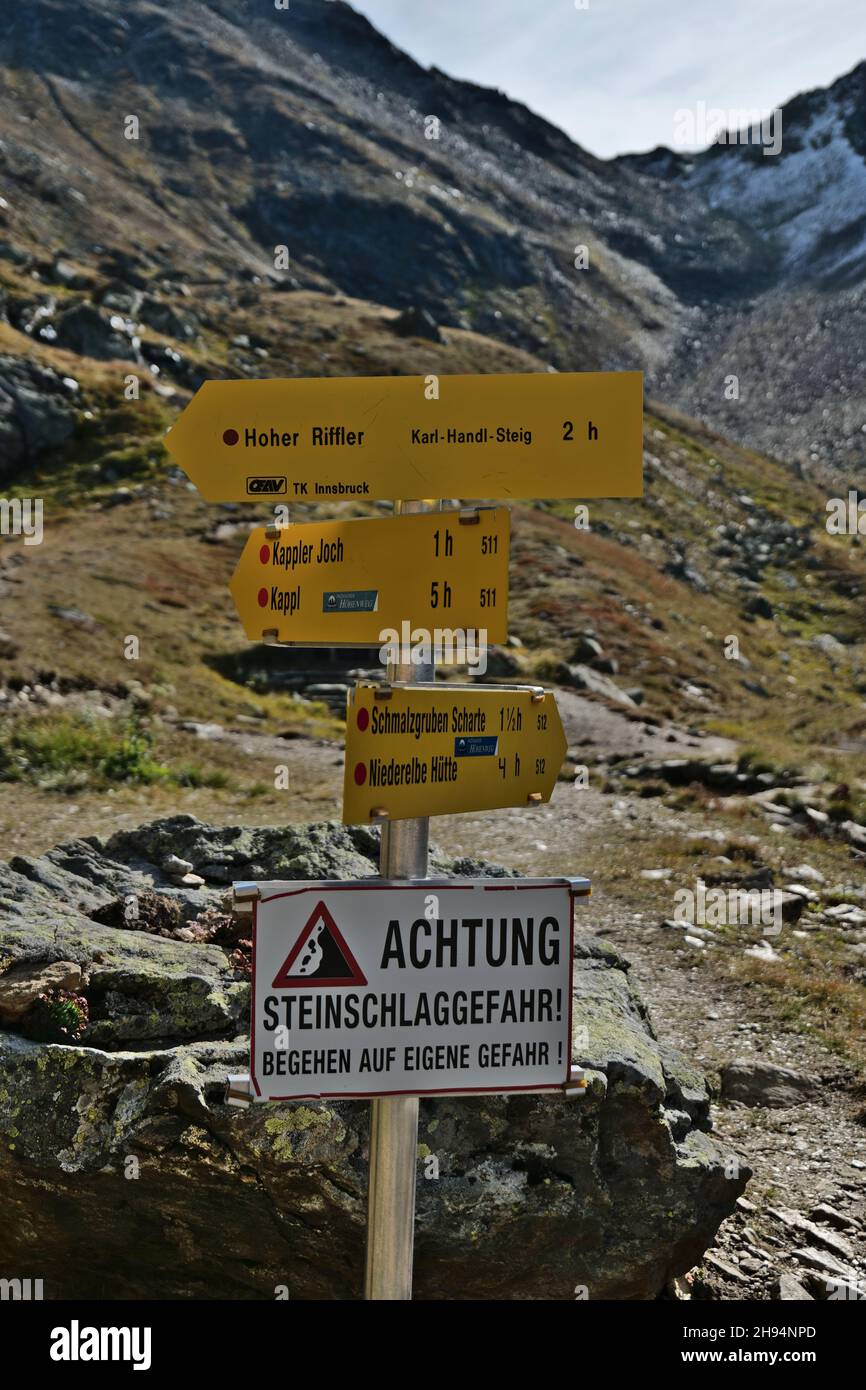 Vertical shot of hiking signs in the Austrian Alps with the danger of ...