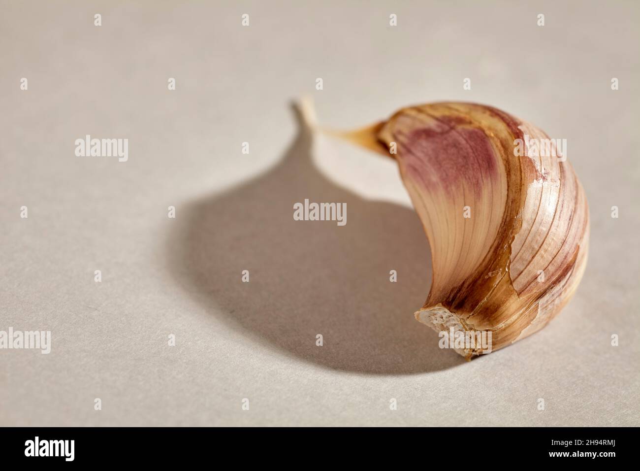 A single, whole, unpeeled clove of garlic Stock Photo - Alamy