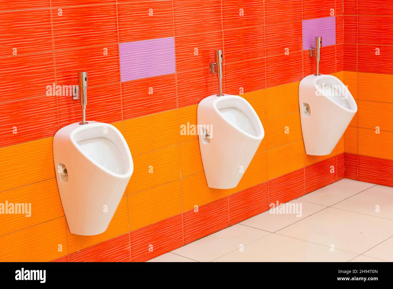 Creative men's toilet in bright orange colors in the mall Stock Photo ...