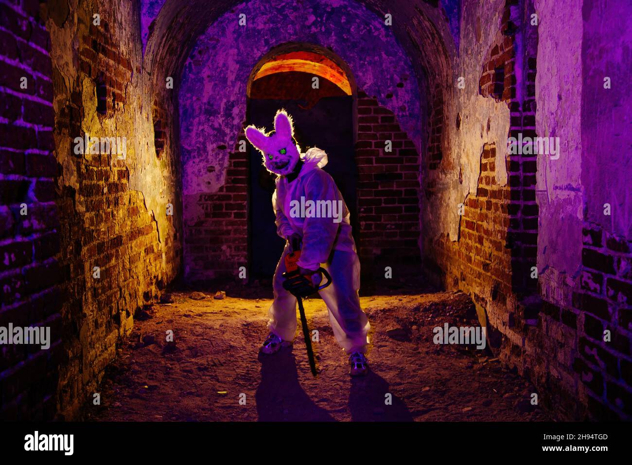 Maniac in mask of scary rabbit with chainsaw Stock Photo - Alamy