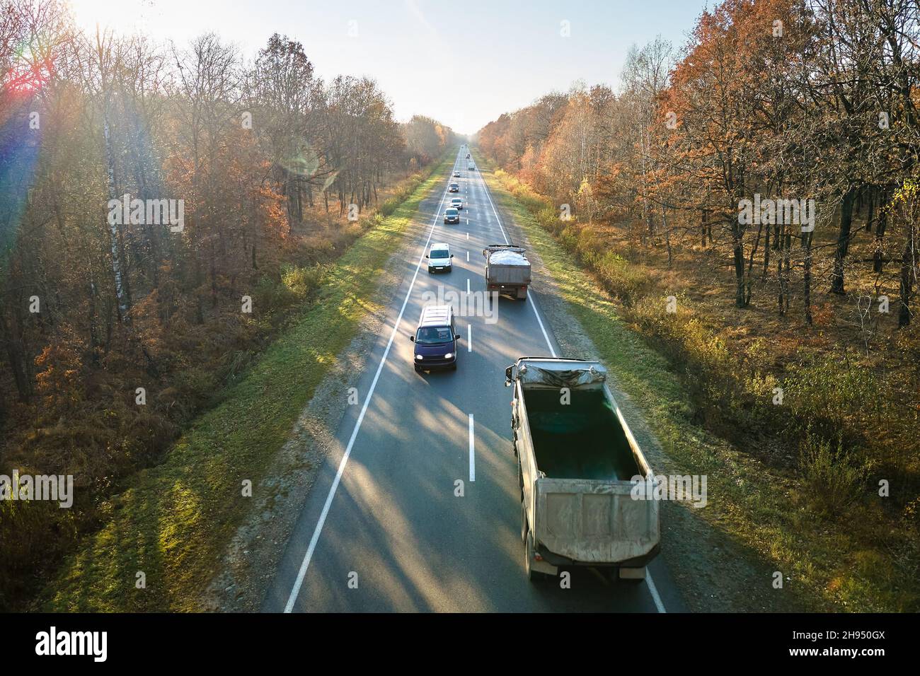 Aerial view of intercity road with fast driving cars between autumn ...