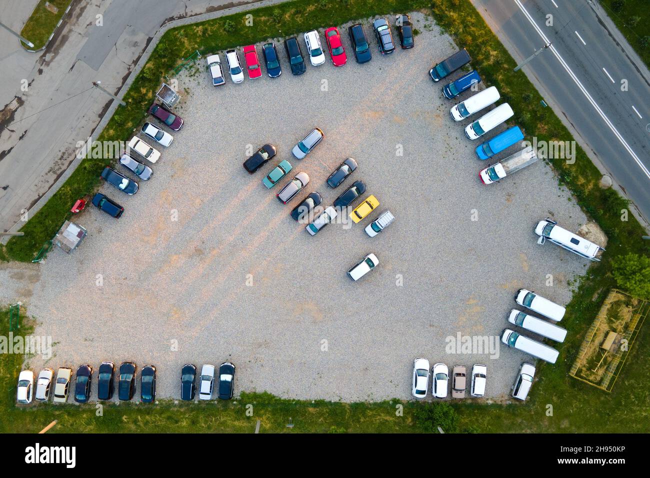 Aerial view of many colorful cars parked on parking lot in evening ...