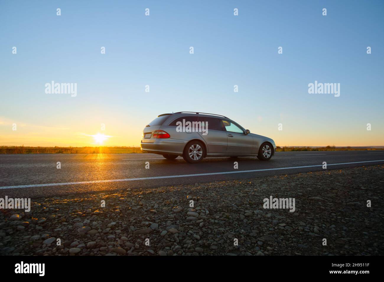 Car driving fast on intercity road at sunset. Highway traffic in ...
