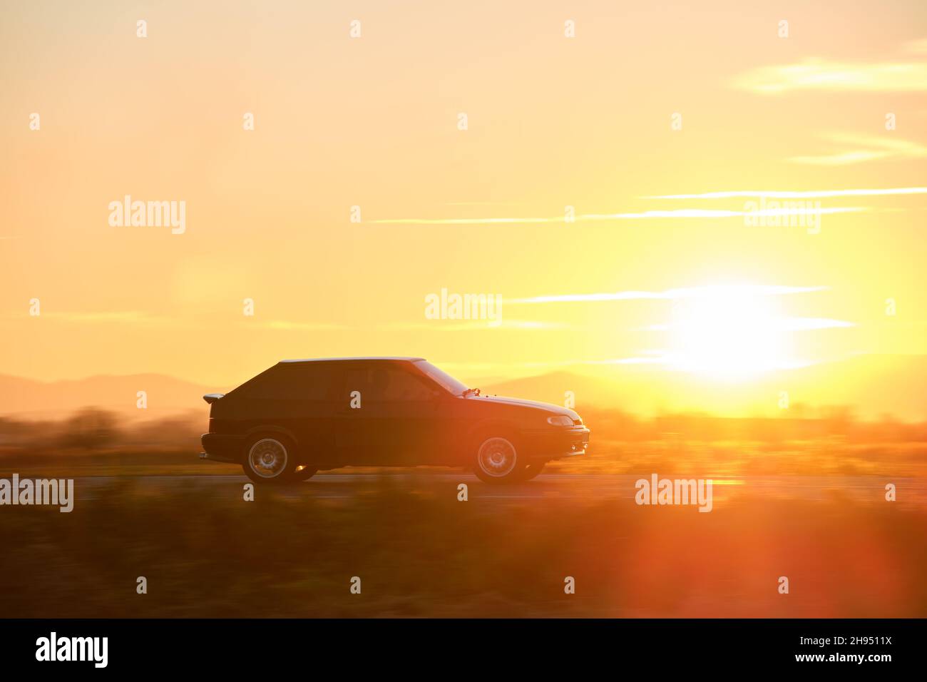 Car driving fast on intercity road at sunset. Highway traffic in ...