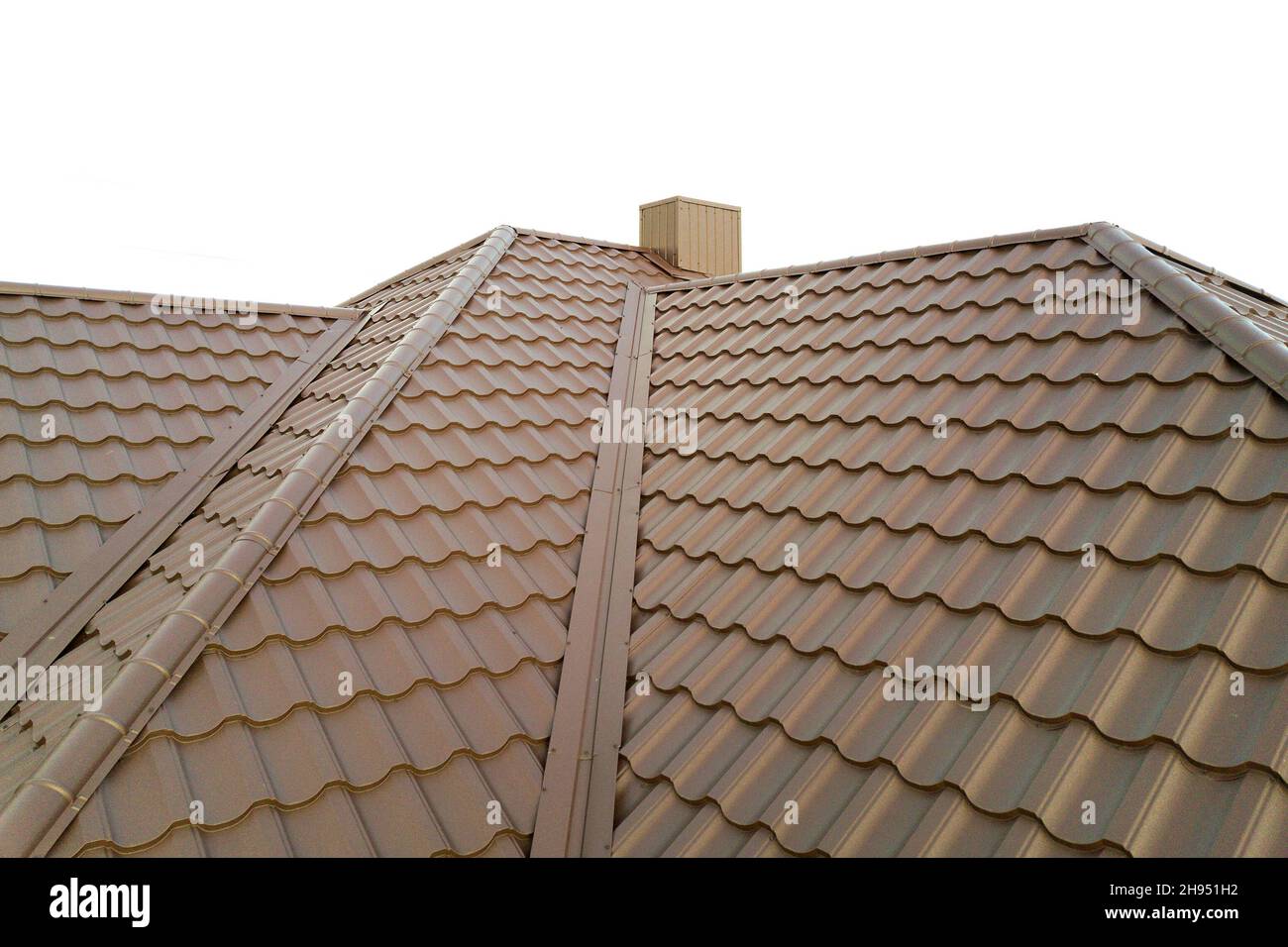 Detail of house roof structure covered with brown metal tile sheets ...