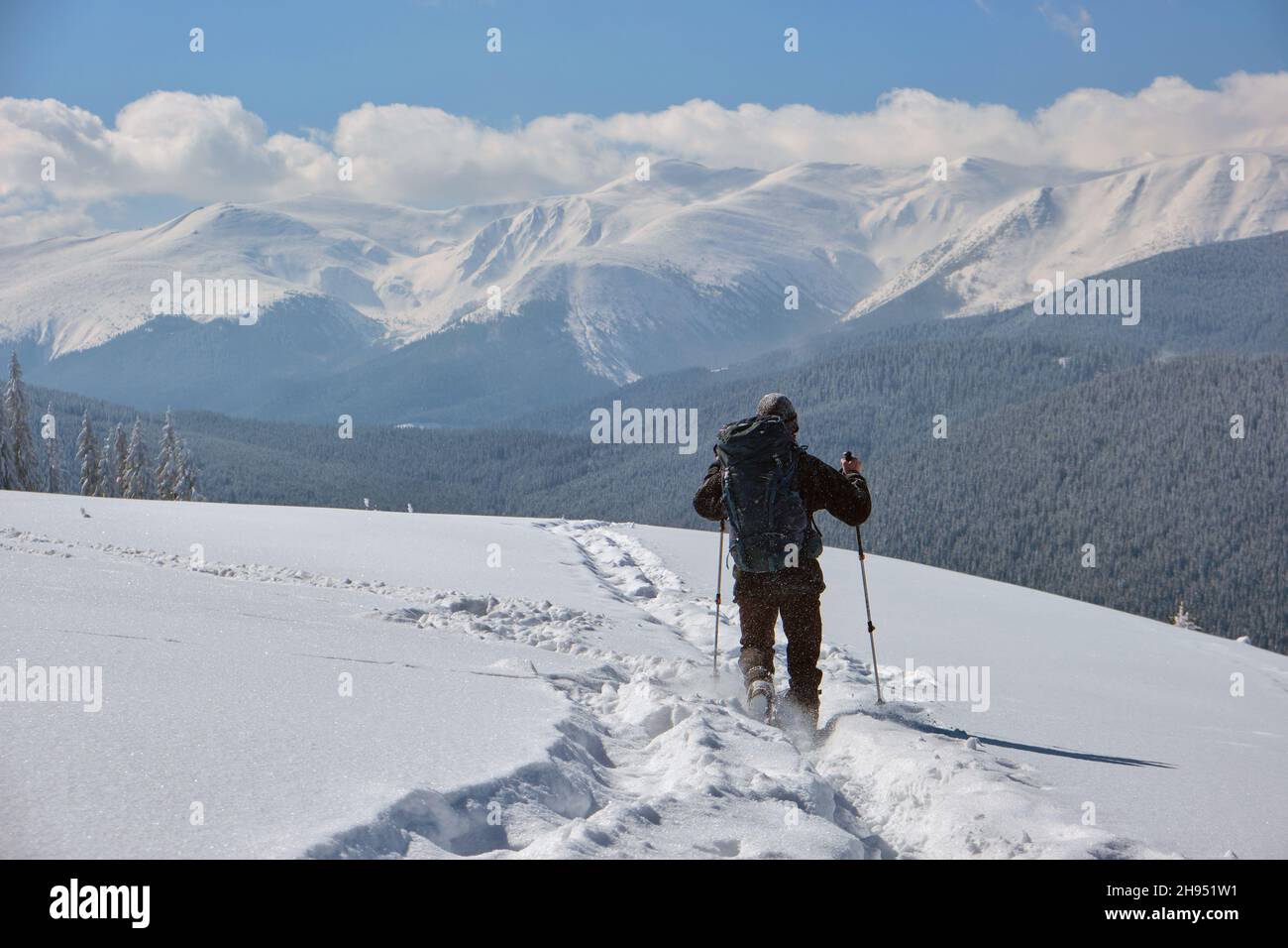 Man backpacker hiking snowy mountain hillside on cold winter day Stock ...