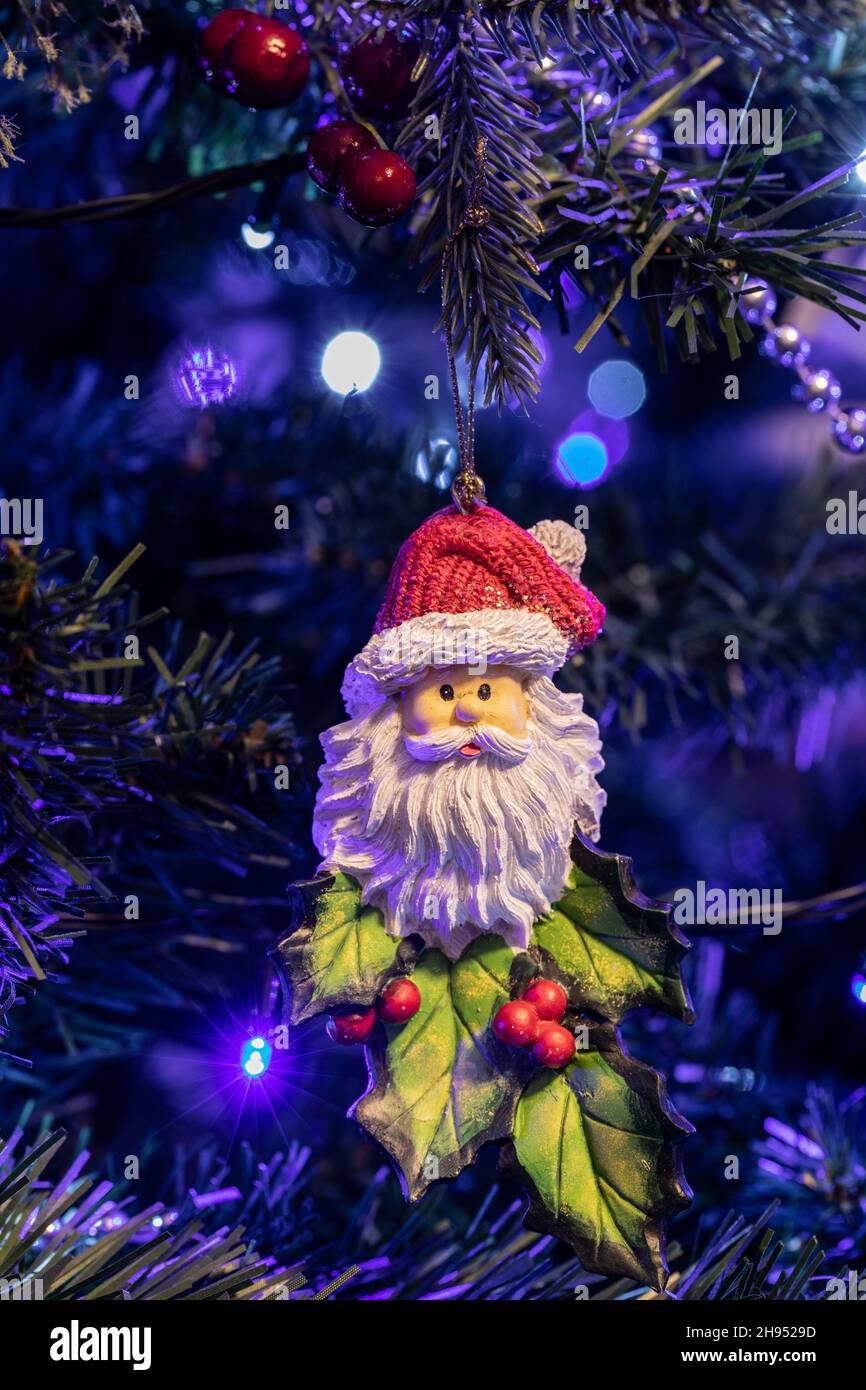 Father Christmas decoration hanging on a Christmas tree with blue and ...