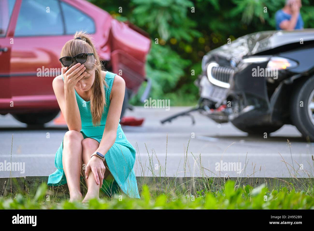 Sad female driver sitting on street side shocked after car accident ...