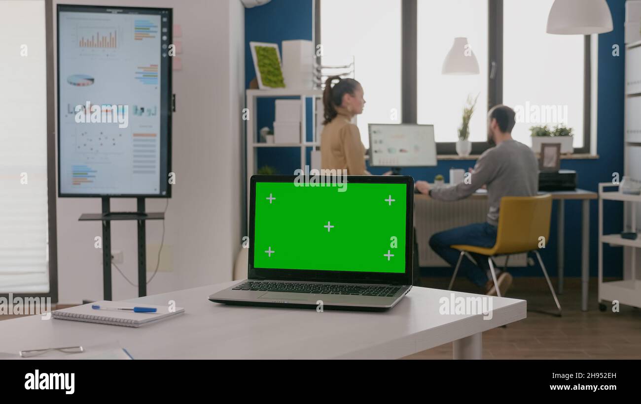 Close up of laptop with green screen at empty desk in office. Computer ...