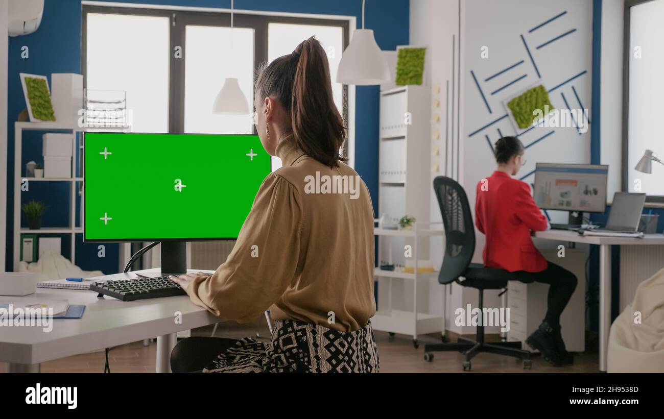 Employee working with green screen on computer in business office ...