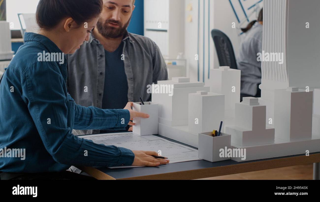 Close Up Of Man And Woman Designing Blueprints Plan Analyzing Building Model Team Of People
