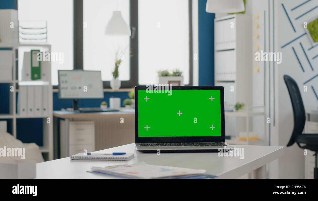 Close up of laptop with green screen in empty office. Nobody at desk ...