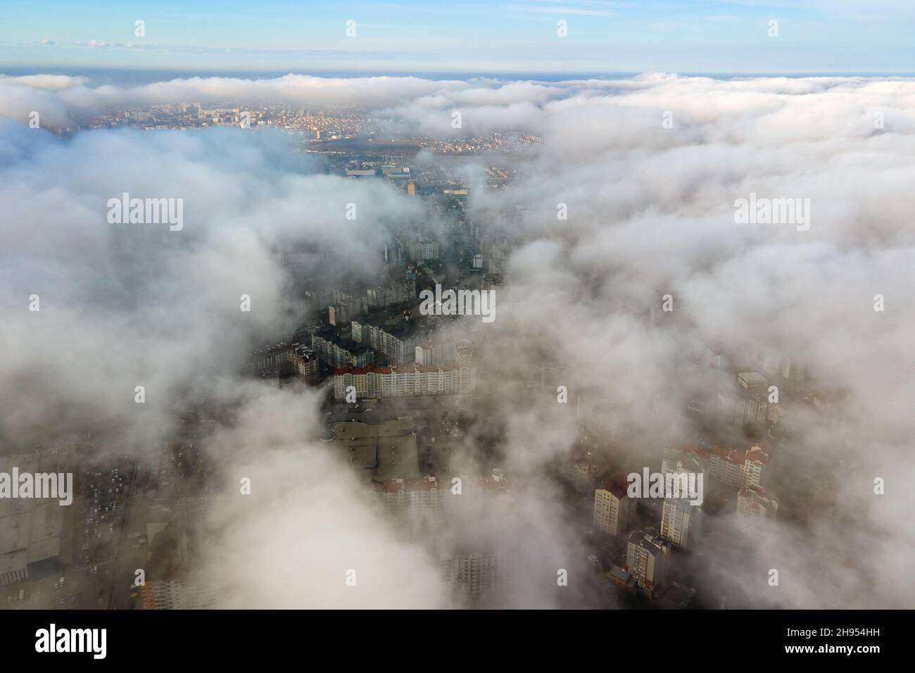 Top aerial view of fluffy white clouds over modern city with high rise ...