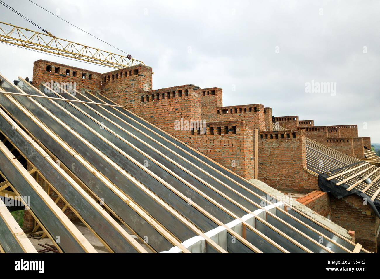 Unfinished brick apartment building with wooden roof structure under ...