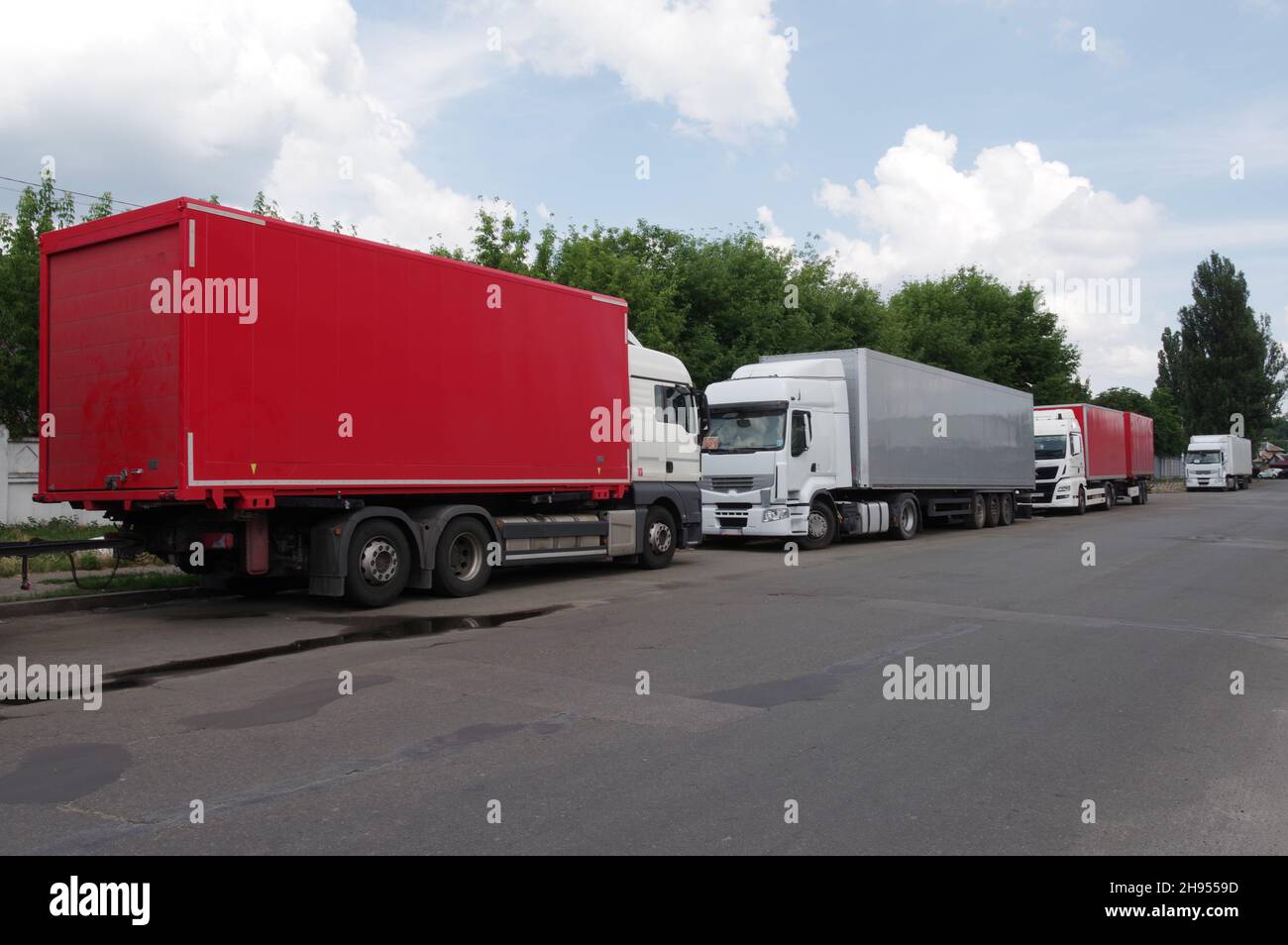 Trucks standing in a row. Trucks with trailers. Freight transportation ...
