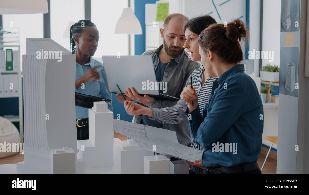 People working with building model to design construction structure and ...