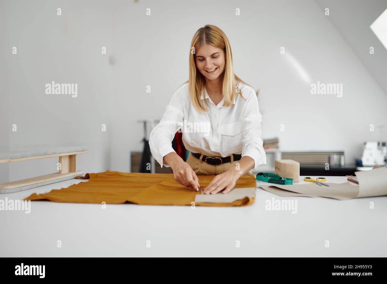 Seamstress works with cloth pattern at workplace Stock Photo - Alamy