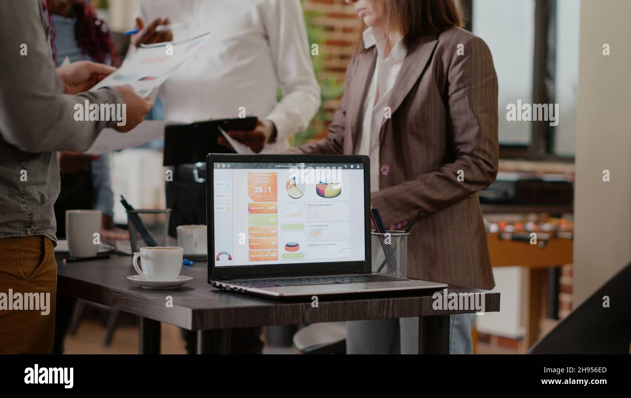 Close up of laptop with business charts on desk in startup office ...