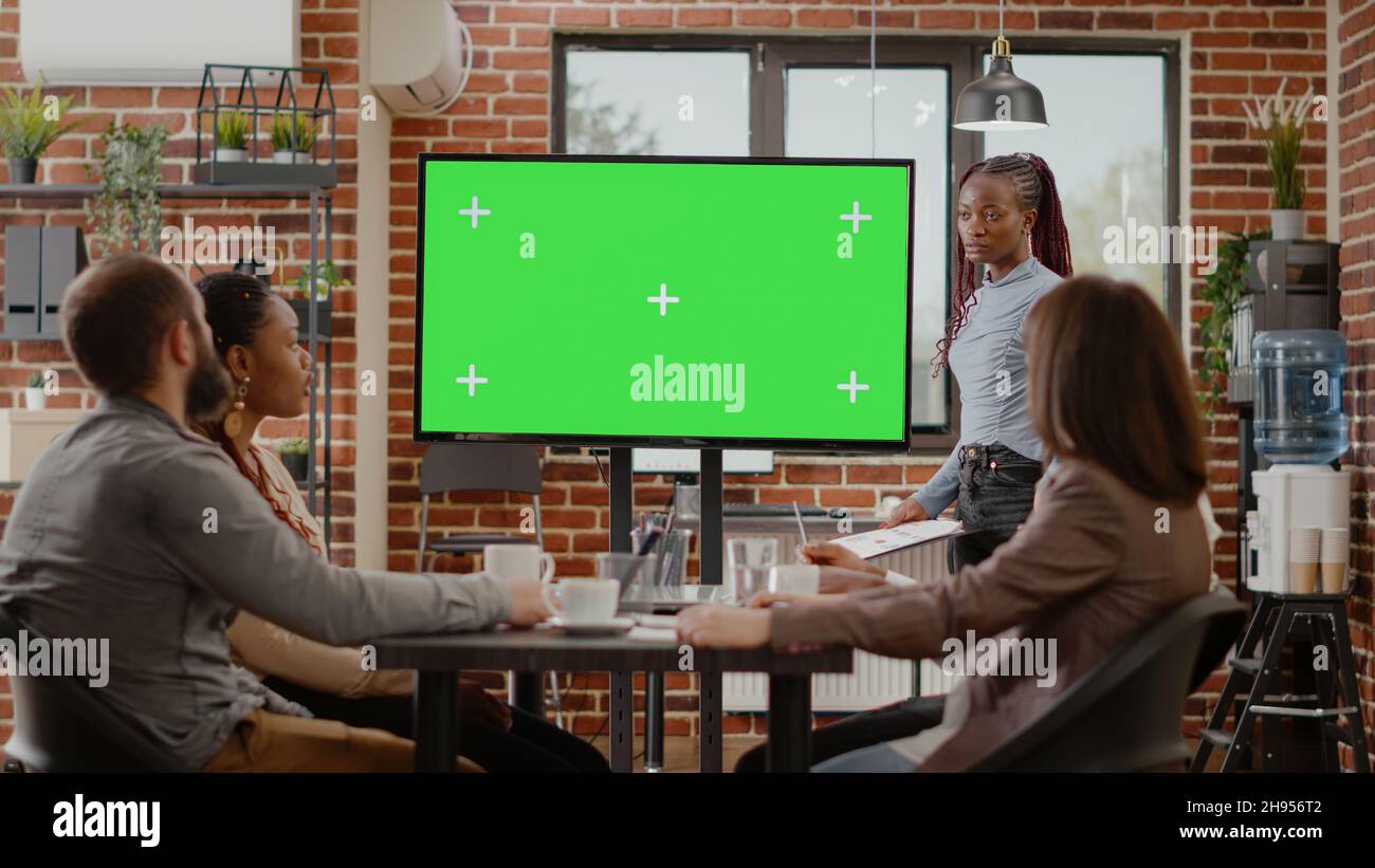 Multi ethnic team working with green screen on display in office ...