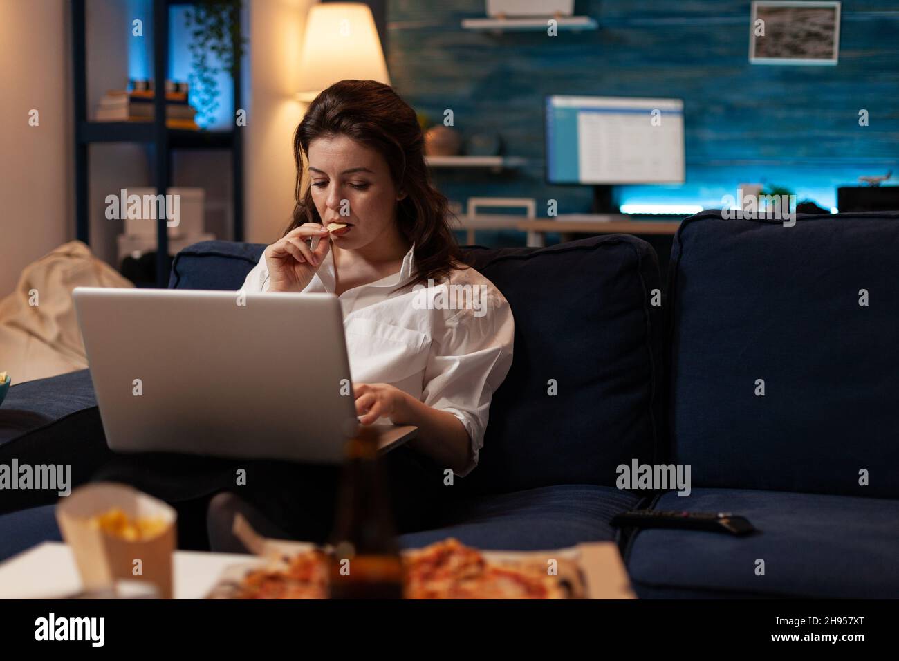 Woman eating potato chips on couch hi-res stock photography and images ...