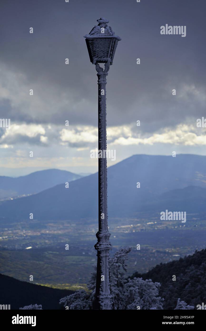 Ancient lamp post in hoar frost standing on the edge of a hill on a ...