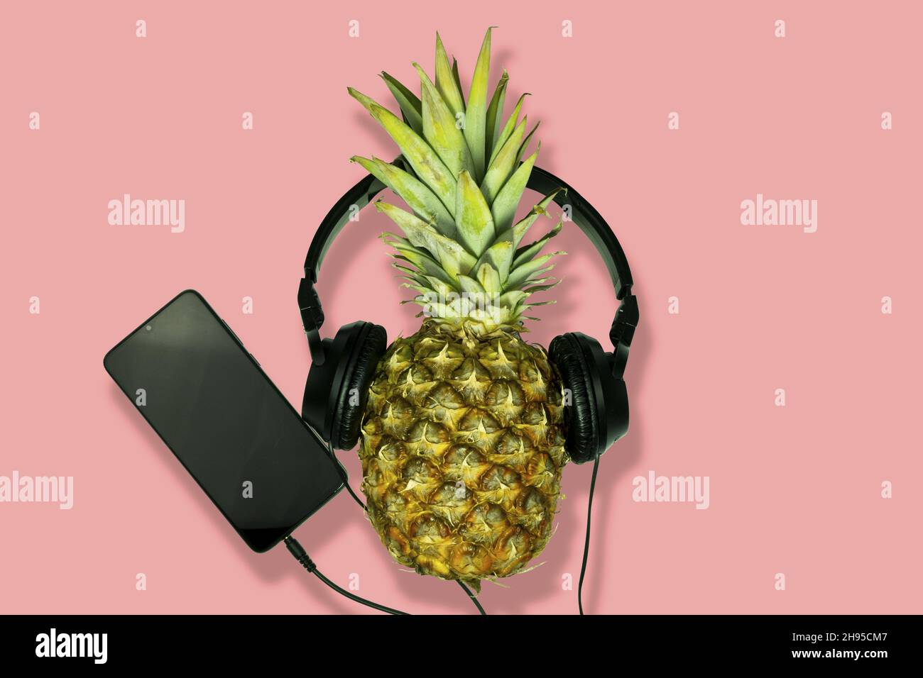 Top view of pineapple with headphones and mobile phone isolated on ...