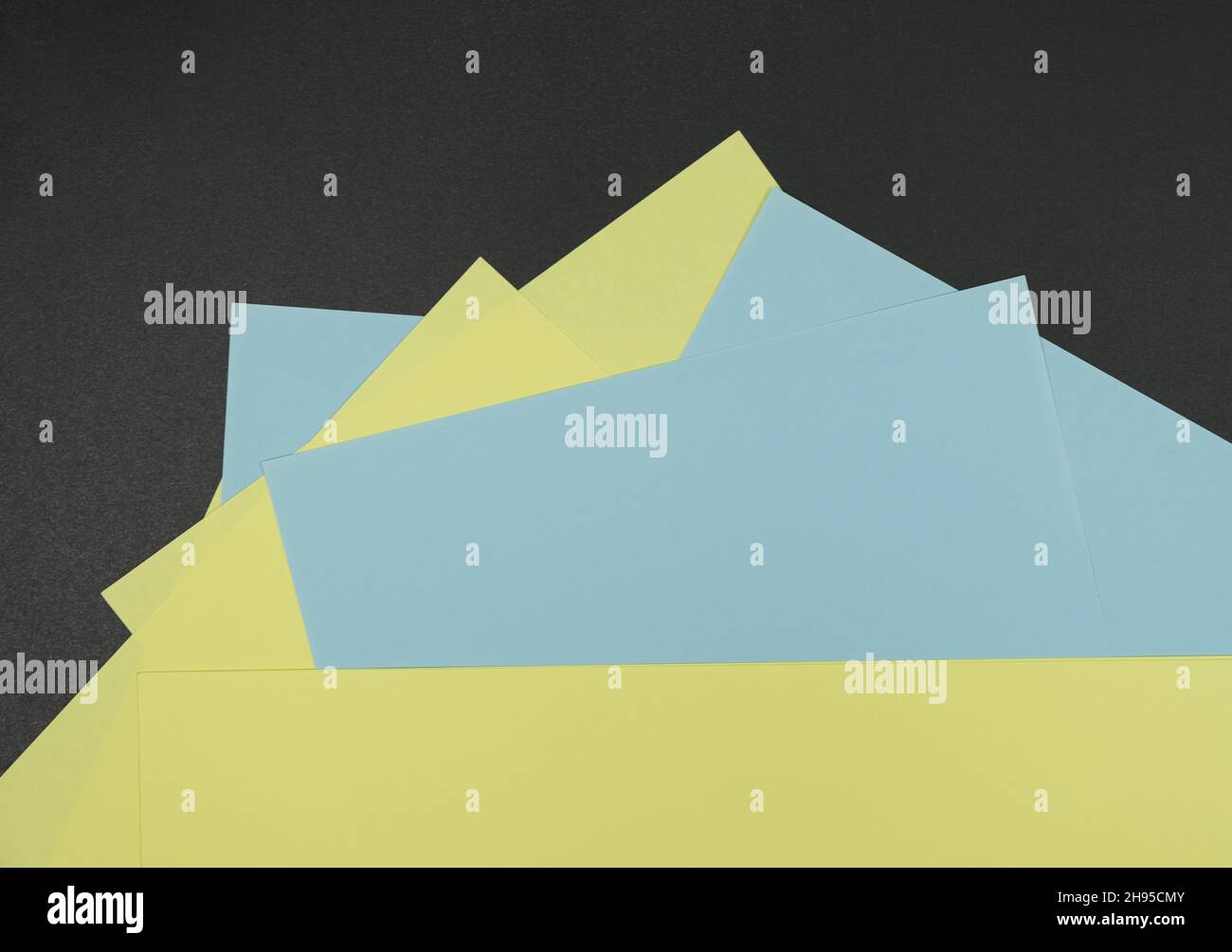 Colored blue and yellow paper background on a black surface with space ...