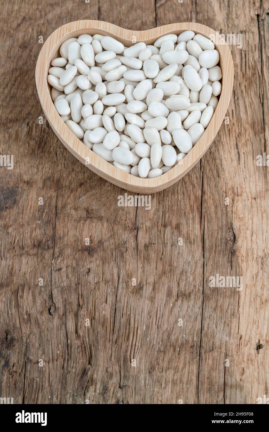 dried beans, raw dried white haricot beans in heart shaped plate on ...