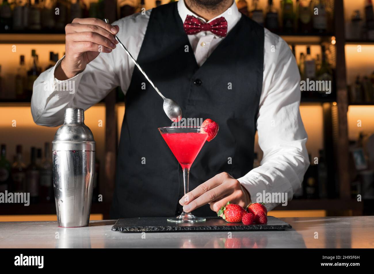 Expert barman is making cocktail at night club. High quality ...