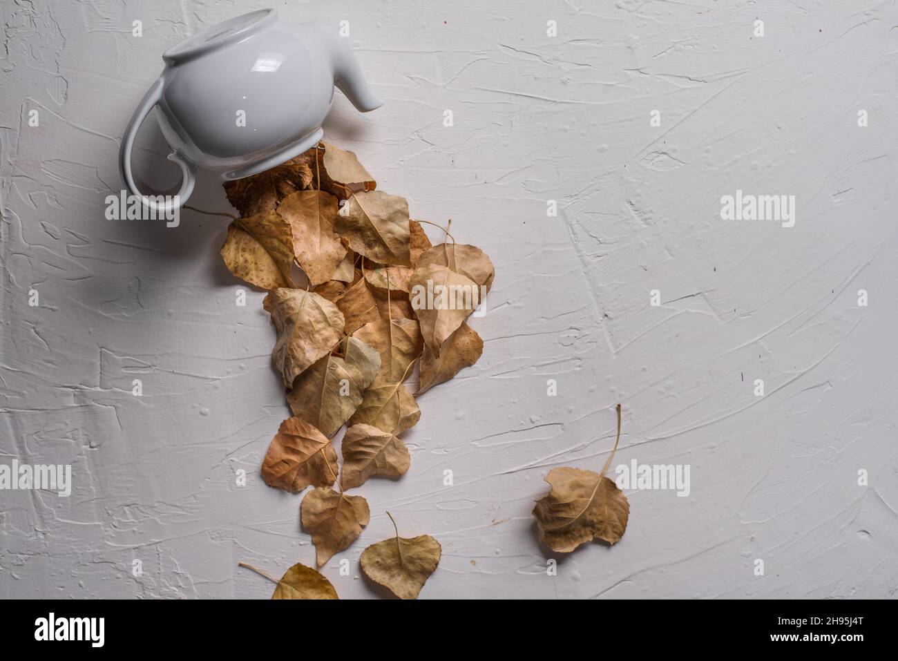 Autumn leaves spilling and flowing out of tea pot Stock Photo - Alamy