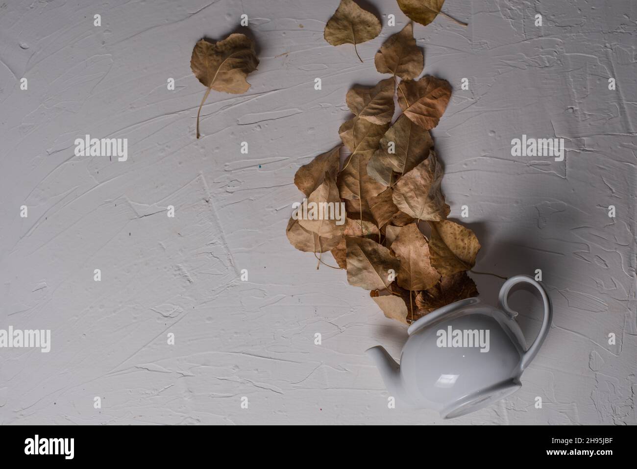 Autumn leaves spilling and flowing out of tea pot Stock Photo - Alamy