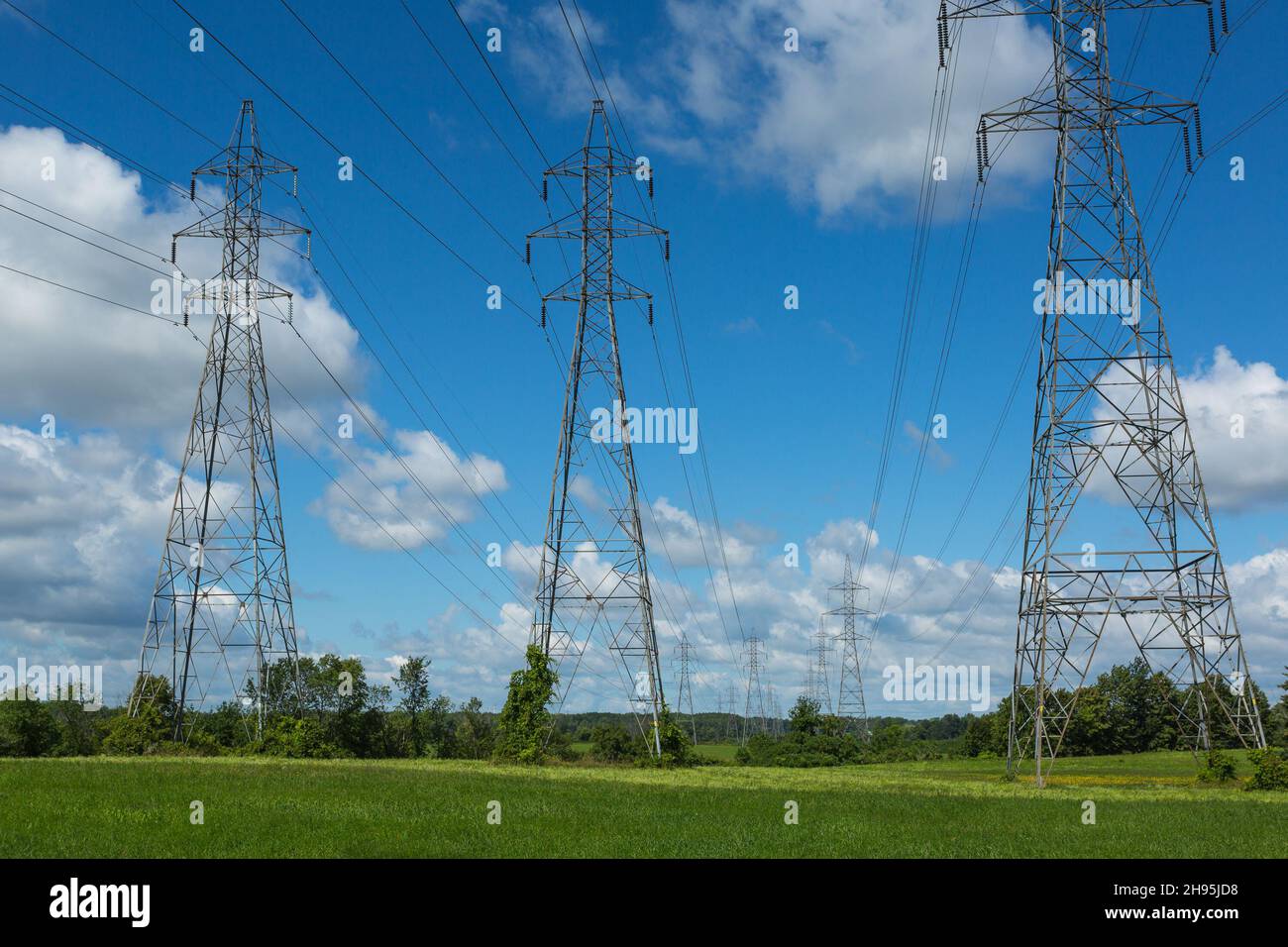 Electric pylons with electrical wires installed in a field and going to ...