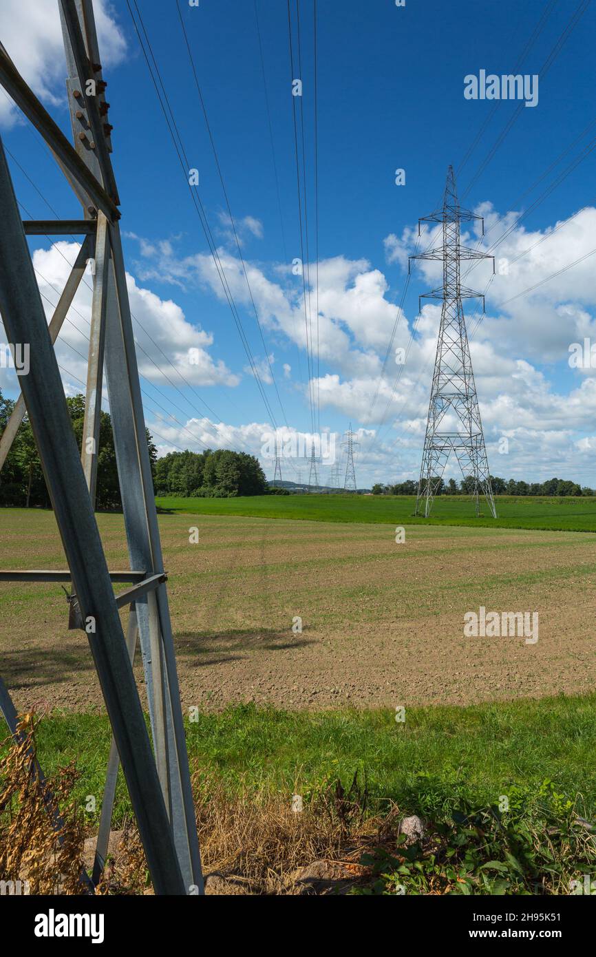 Electric pylons with electrical wires installed in a field and going to ...
