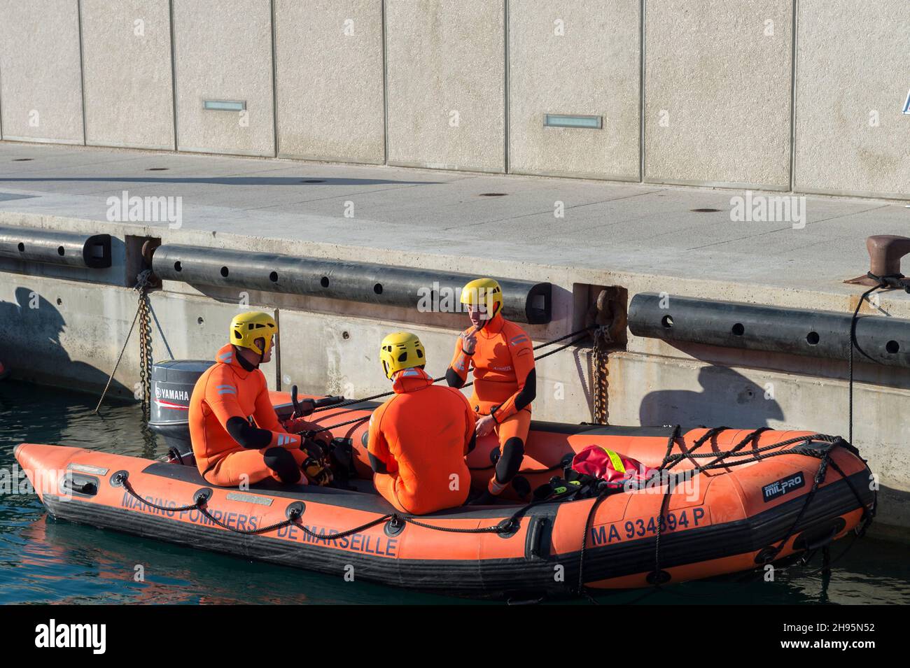 Three firefighters at the sea are seen on their fast response boat in ...