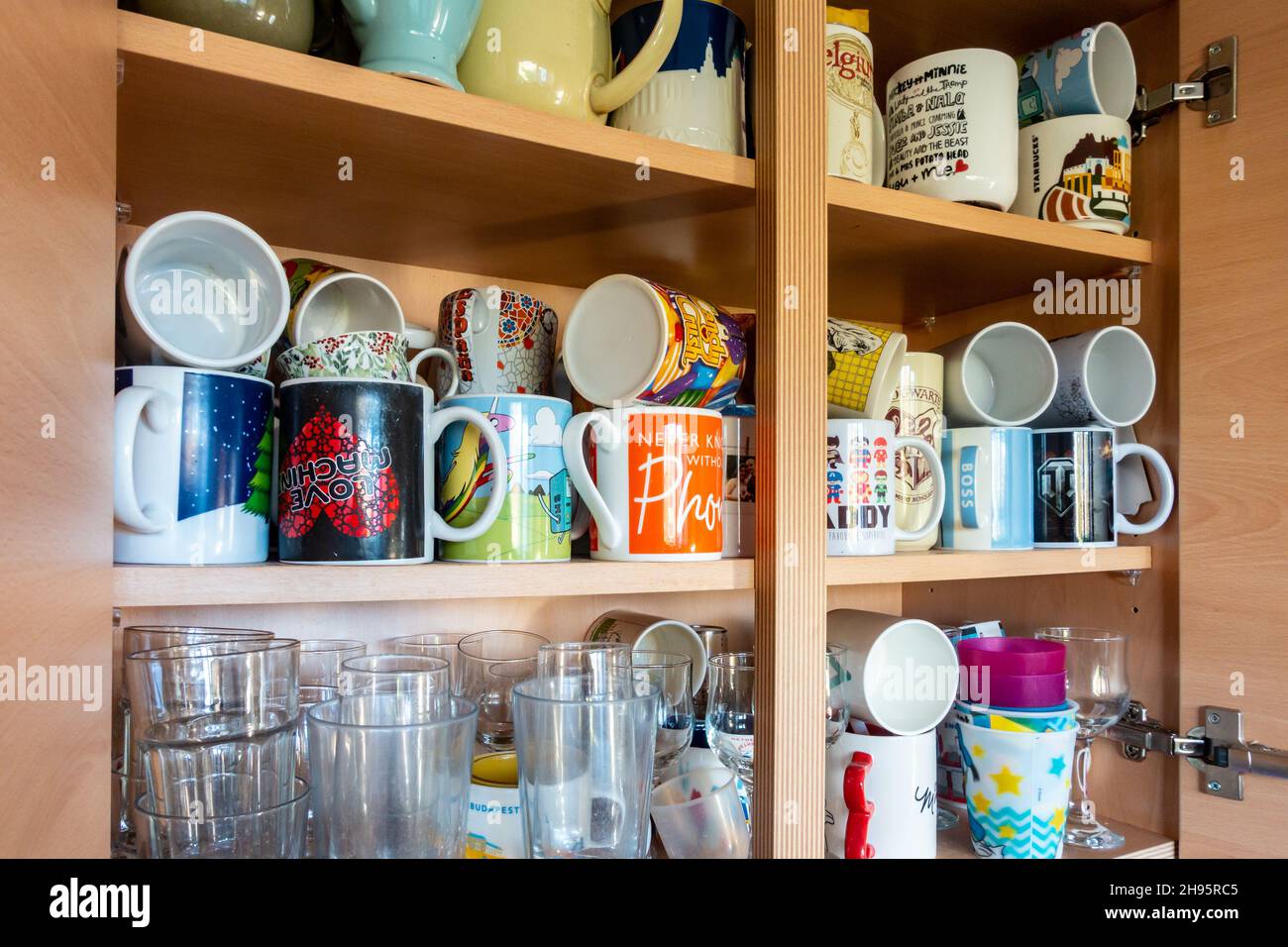 Cups, mugs and glasses in a kitchen cupboard Stock Photo - Alamy