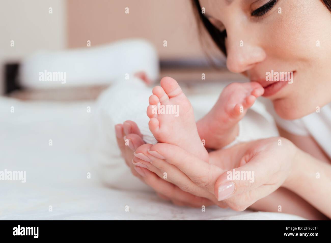Woman touching feet of newborn baby with hands Stock Photo - Alamy