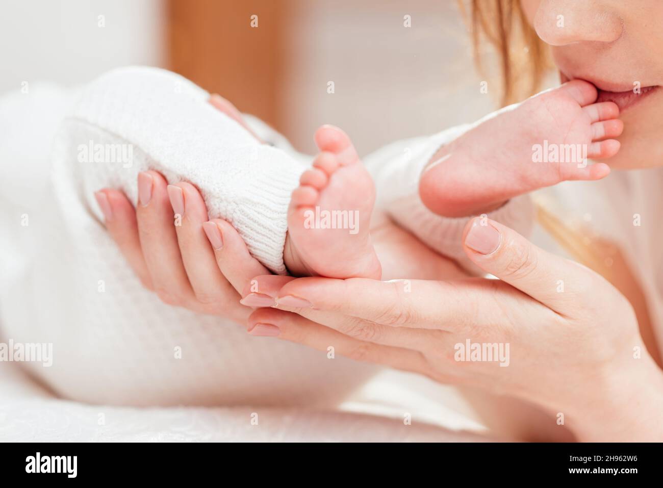 Woman touching feet of newborn baby with hands Stock Photo - Alamy