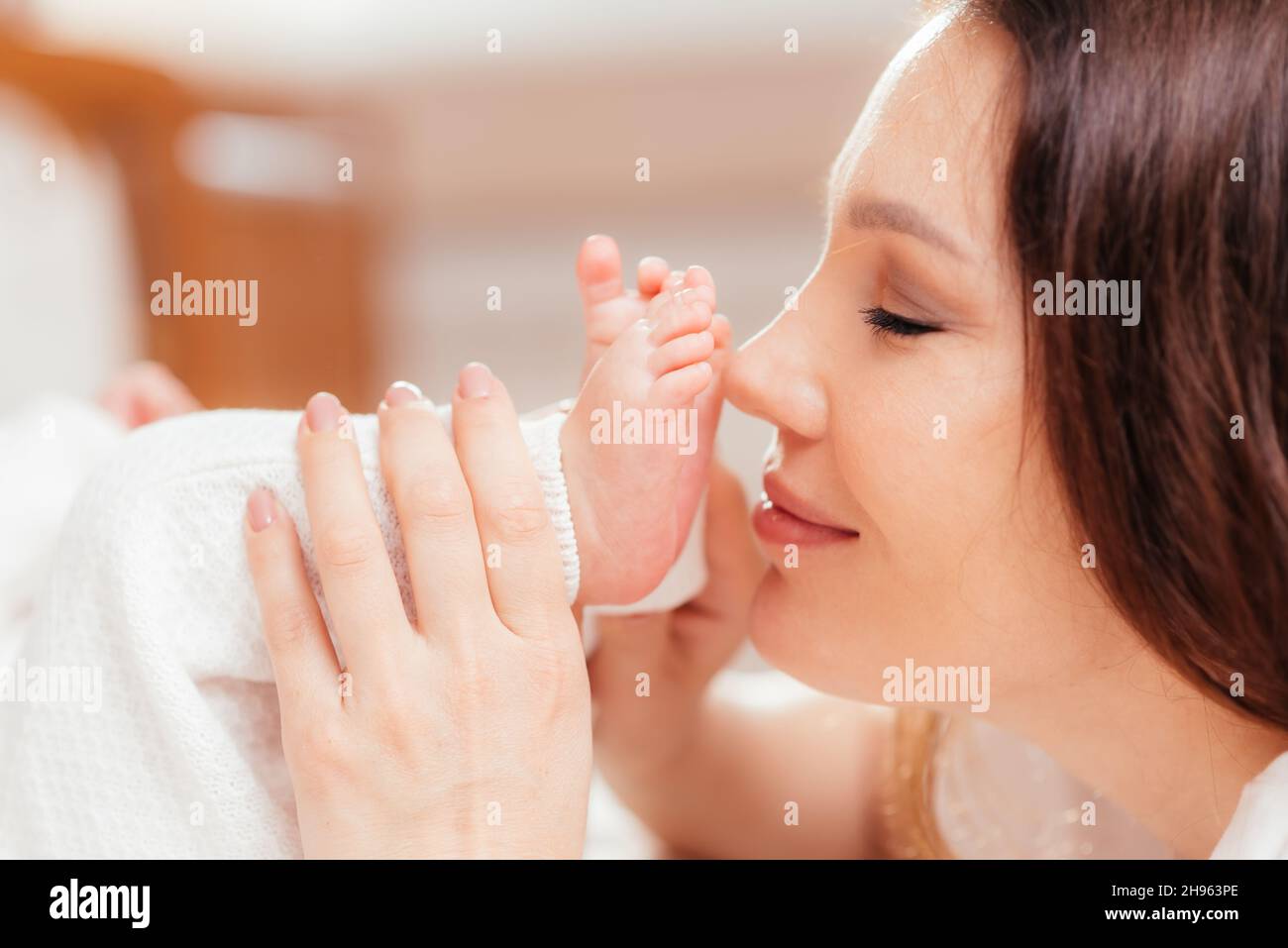 Woman touching feet of newborn baby with hands Stock Photo - Alamy