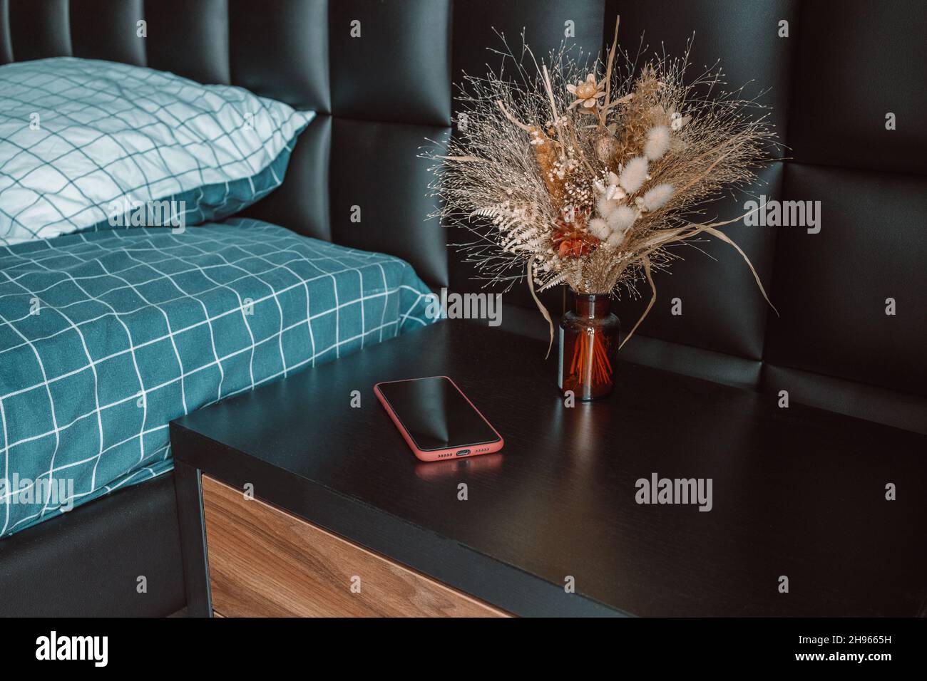 Black smartphone on nightstand near bed in room. Modern interior Stock ...