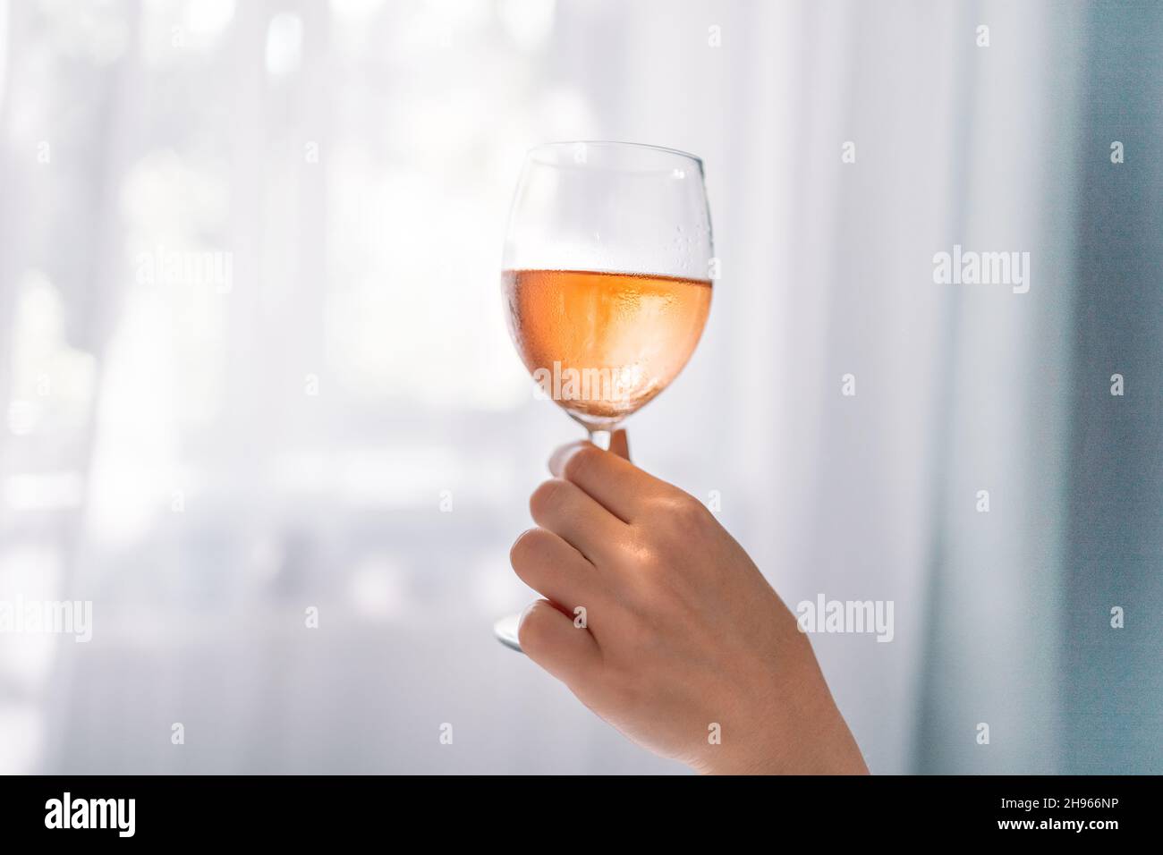 Drinking wine early tomorrow. Woman hand holding glass of wine. Morning ...