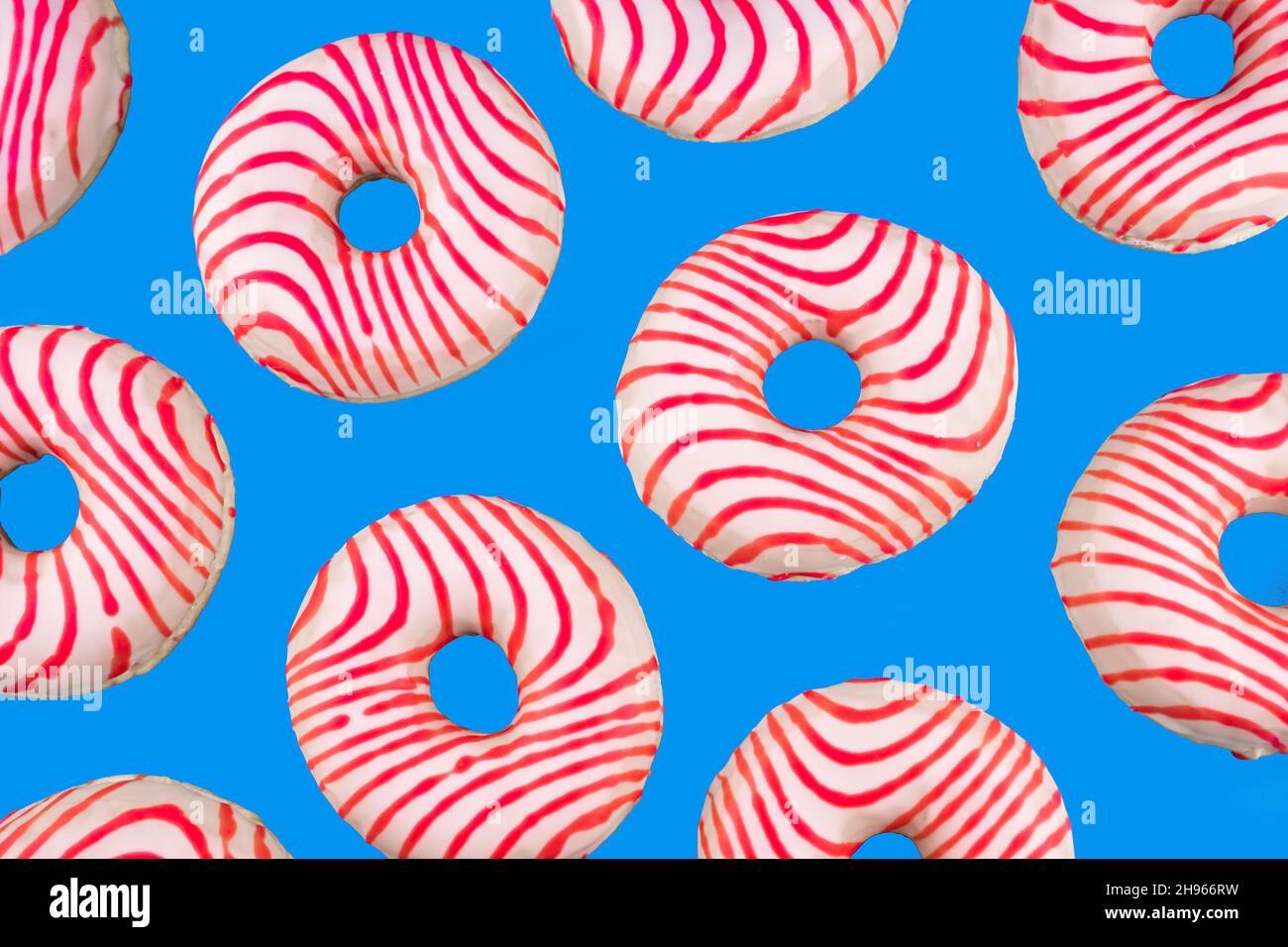 Flat lay donuts on a blue background. Top view. Pink and white donuts ...