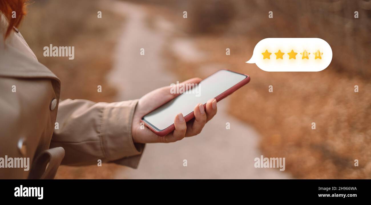 Excellent. Person using mobile phone with icon five star symbol to ...