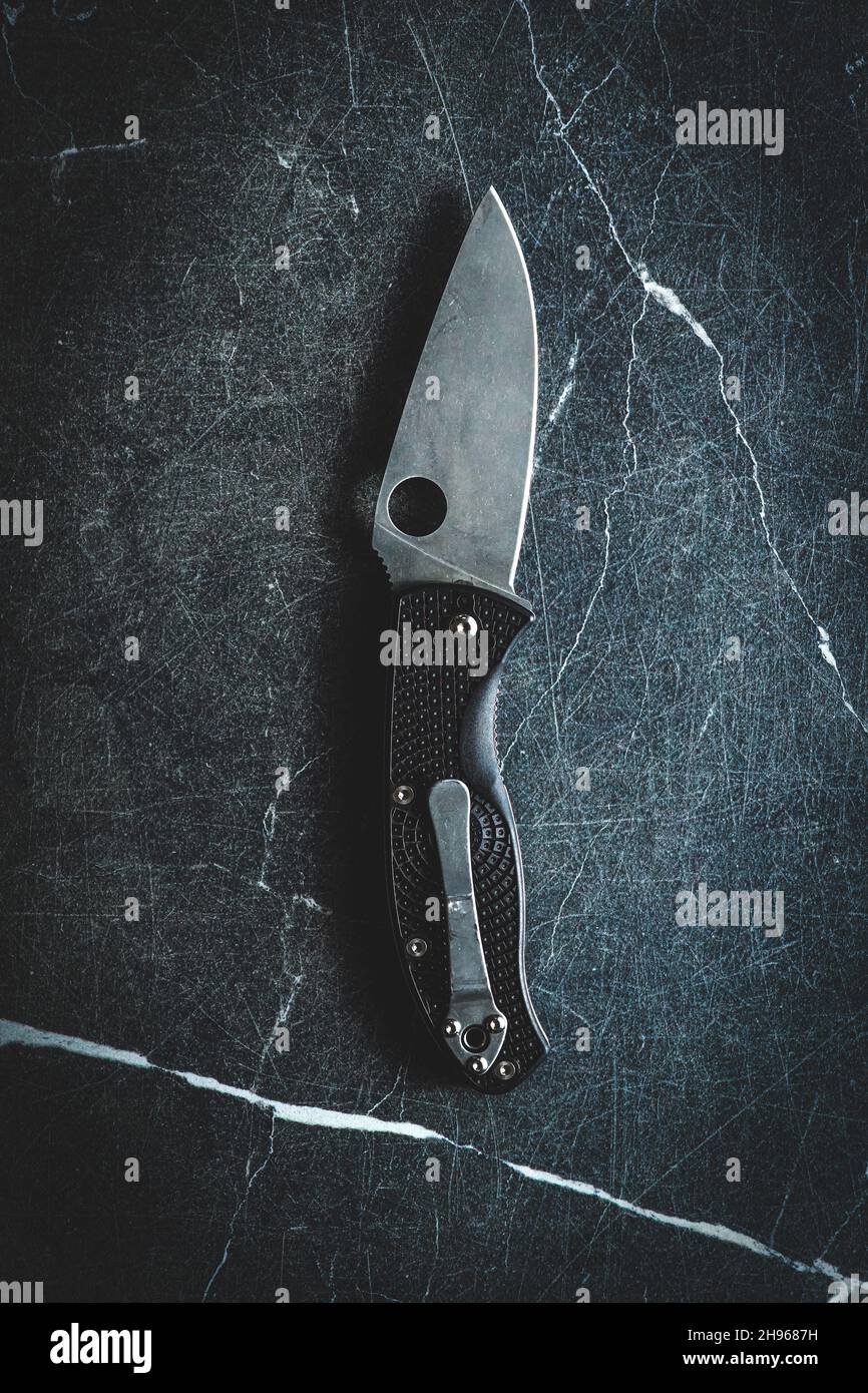 Top view of a folding knife on a marble surface Stock Photo - Alamy