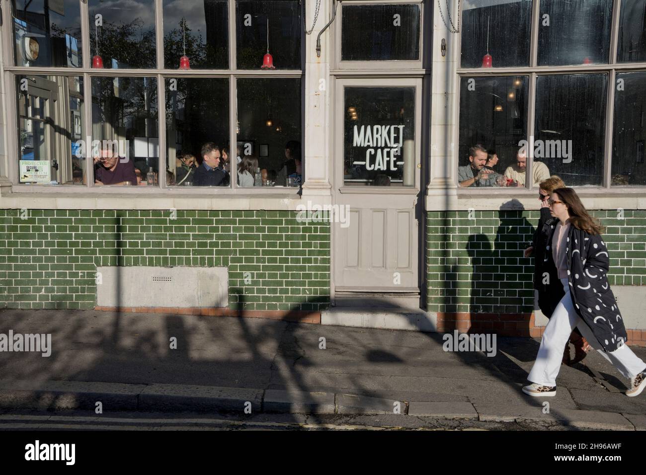 People eating and drinking at a cafe in Broadway market in Hackney ...