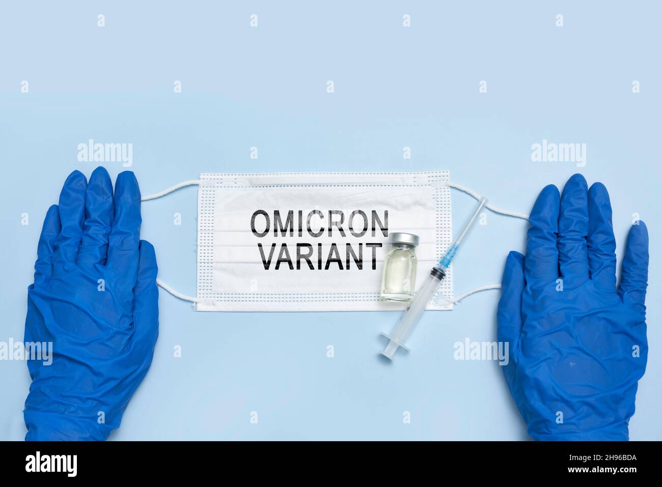 Female doctor holds a face mask with - Omicron variant text on it ...