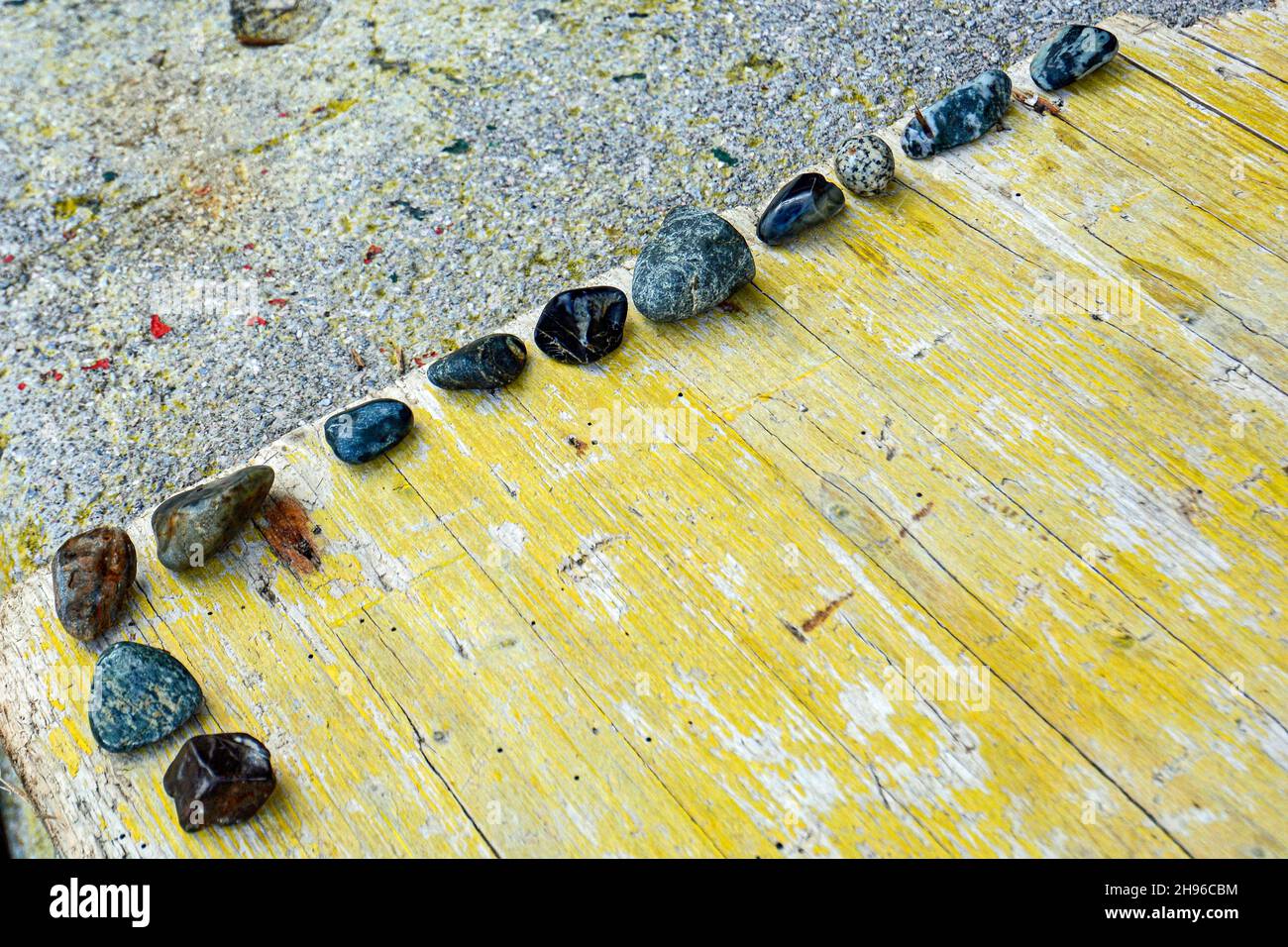 Different types of stones lined up on a wooden surface Stock Photo - Alamy
