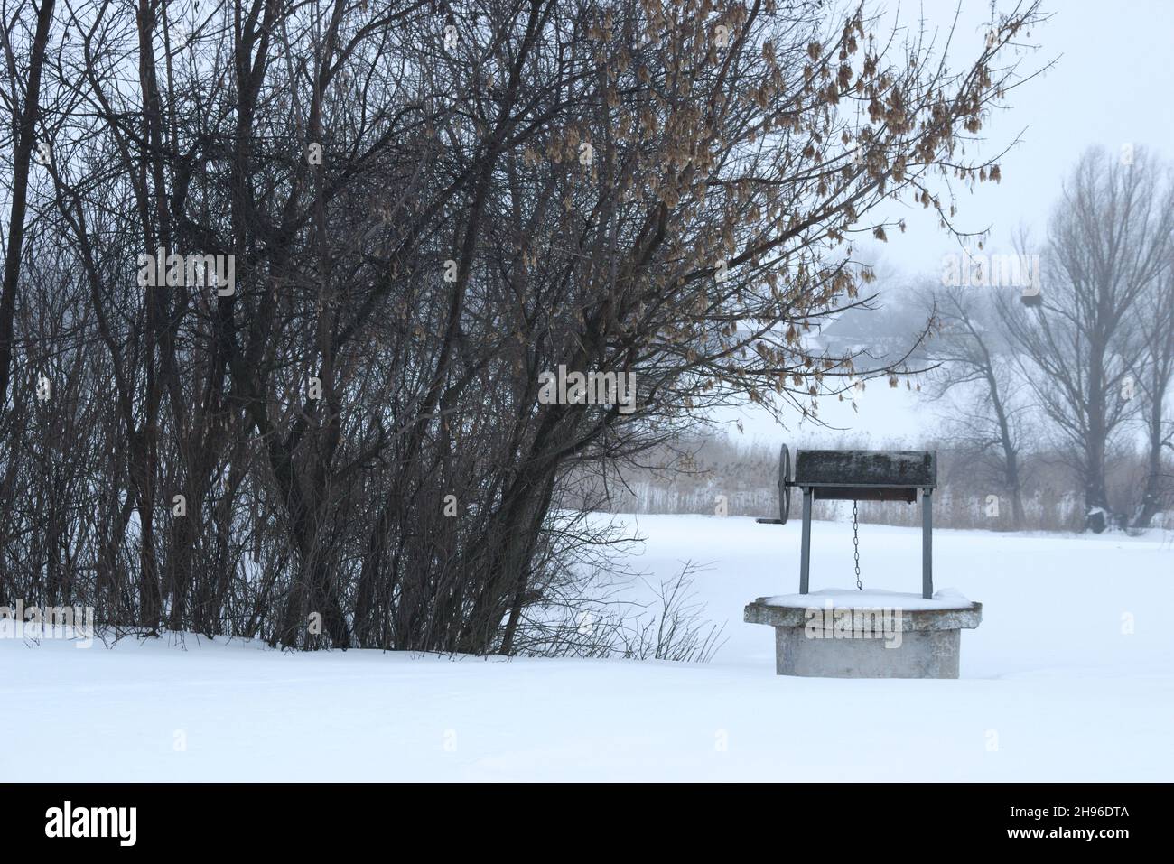 Old abandoned well on the snowy field Stock Photo - Alamy