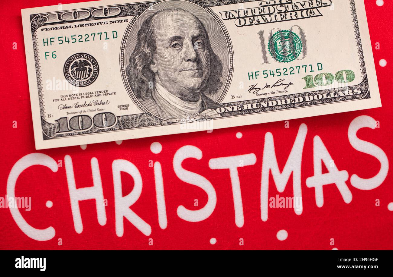 US 100 dollar banknote and Merry Christmas text on red background for ...