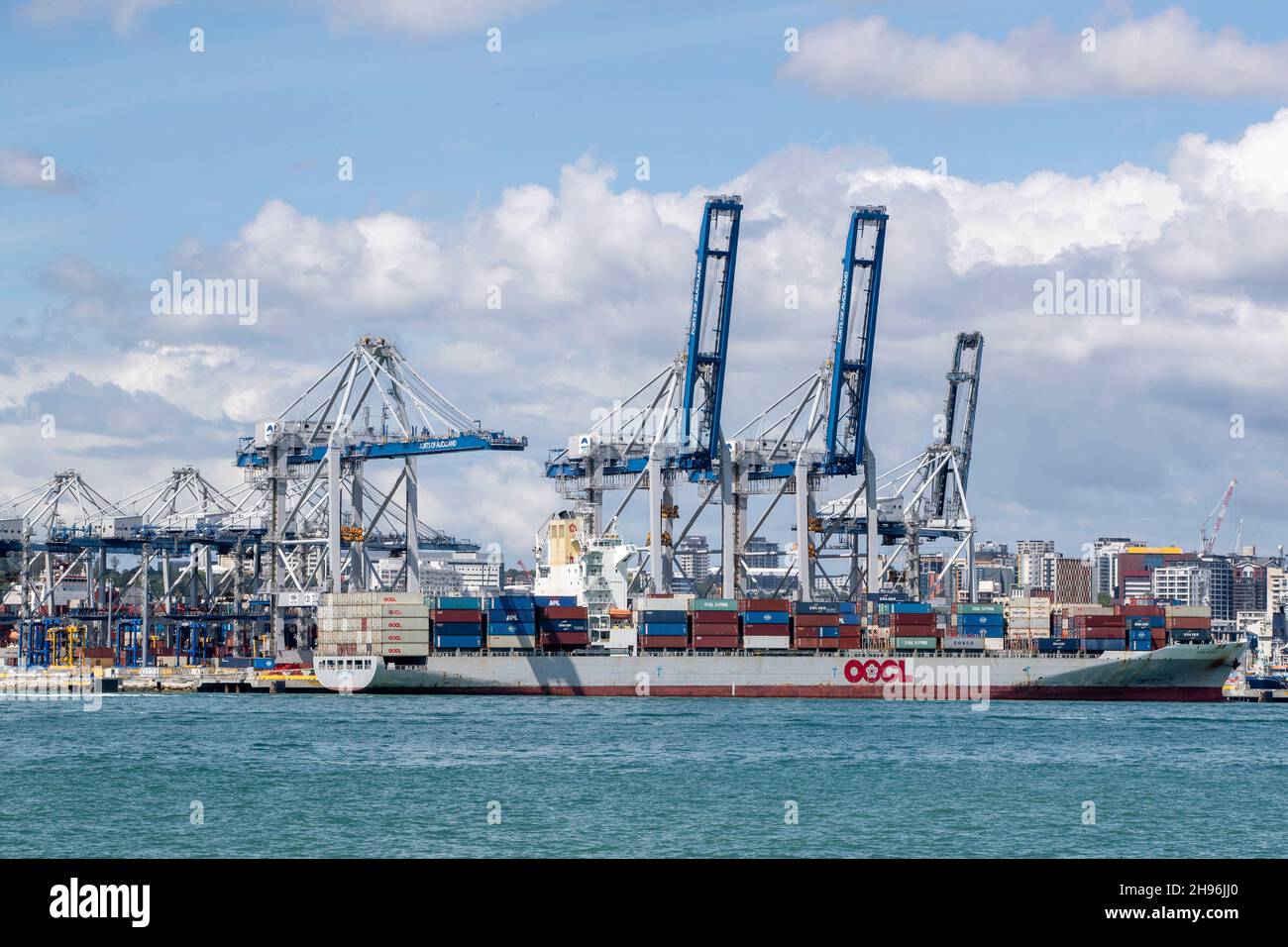 Dockyard cranes unloading the container ship OOCL Busan at a wharf at ...